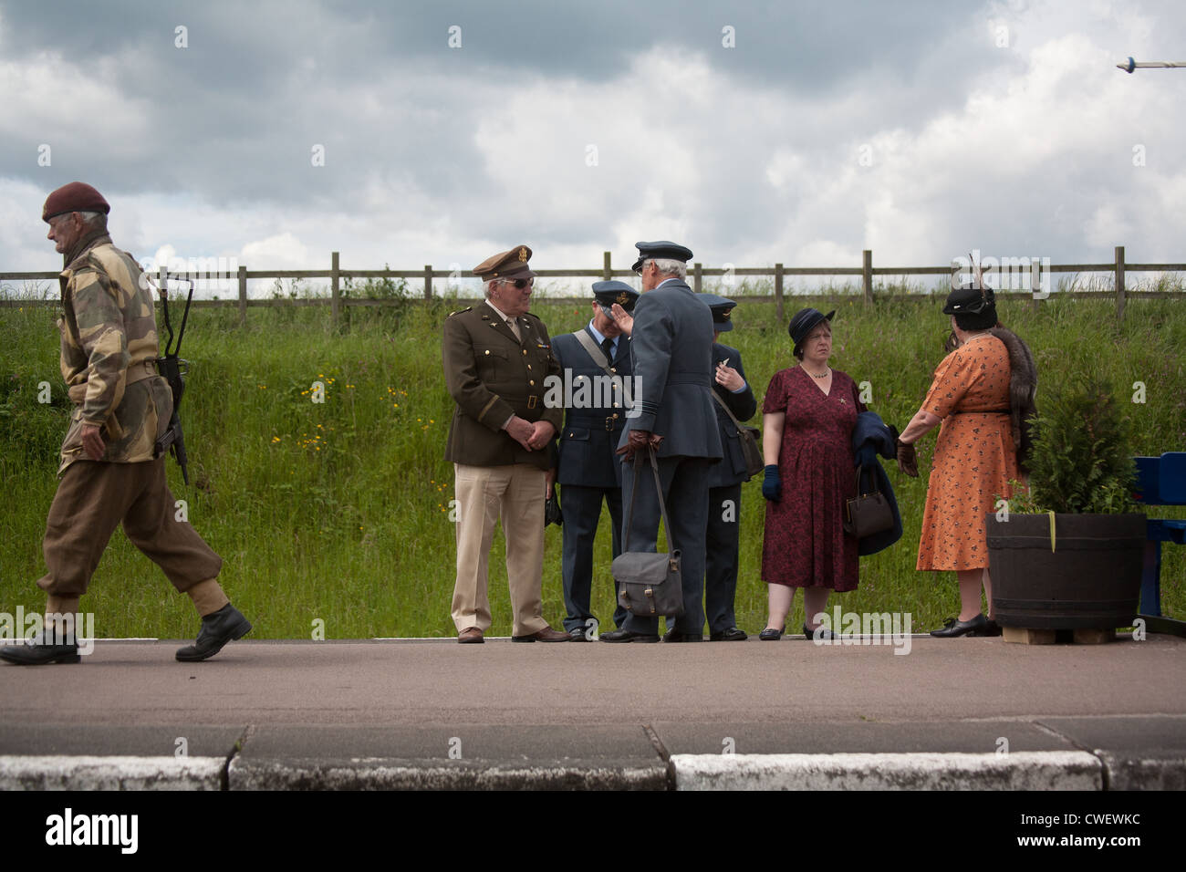 Group of civilians and armed forces on railway platform Stock Photo - Alamy