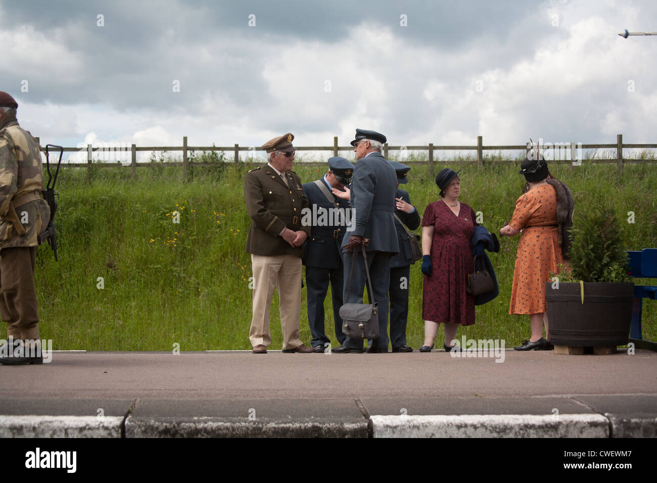 Group of civilians and armed forces on railway platform Stock Photo - Alamy