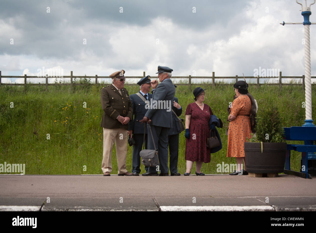 Group of civilians and armed forces on railway platform Stock Photo - Alamy