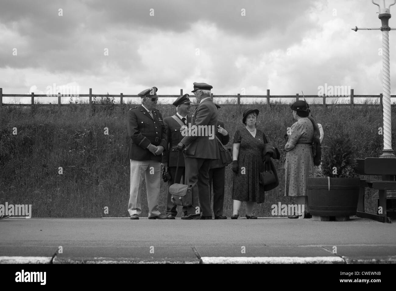 Group of civilians and armed forces on railway platform Stock Photo - Alamy