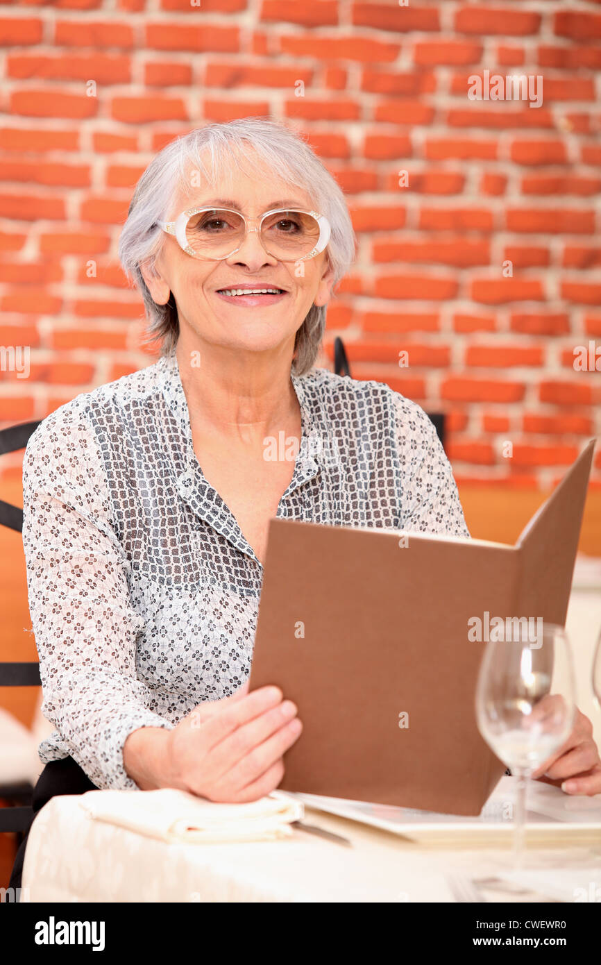 Woman reading a menu in a restaurant Stock Photo - Alamy