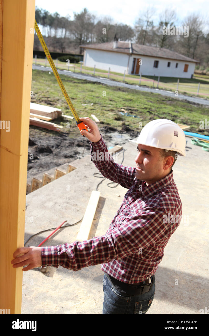 Man measuring wood beam Stock Photo - Alamy
