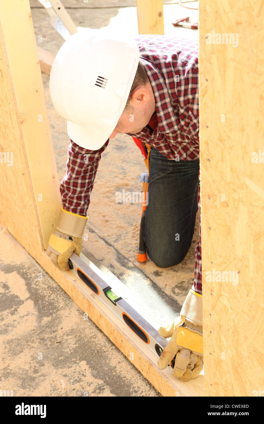 Builder using a bubble level Stock Photo - Alamy