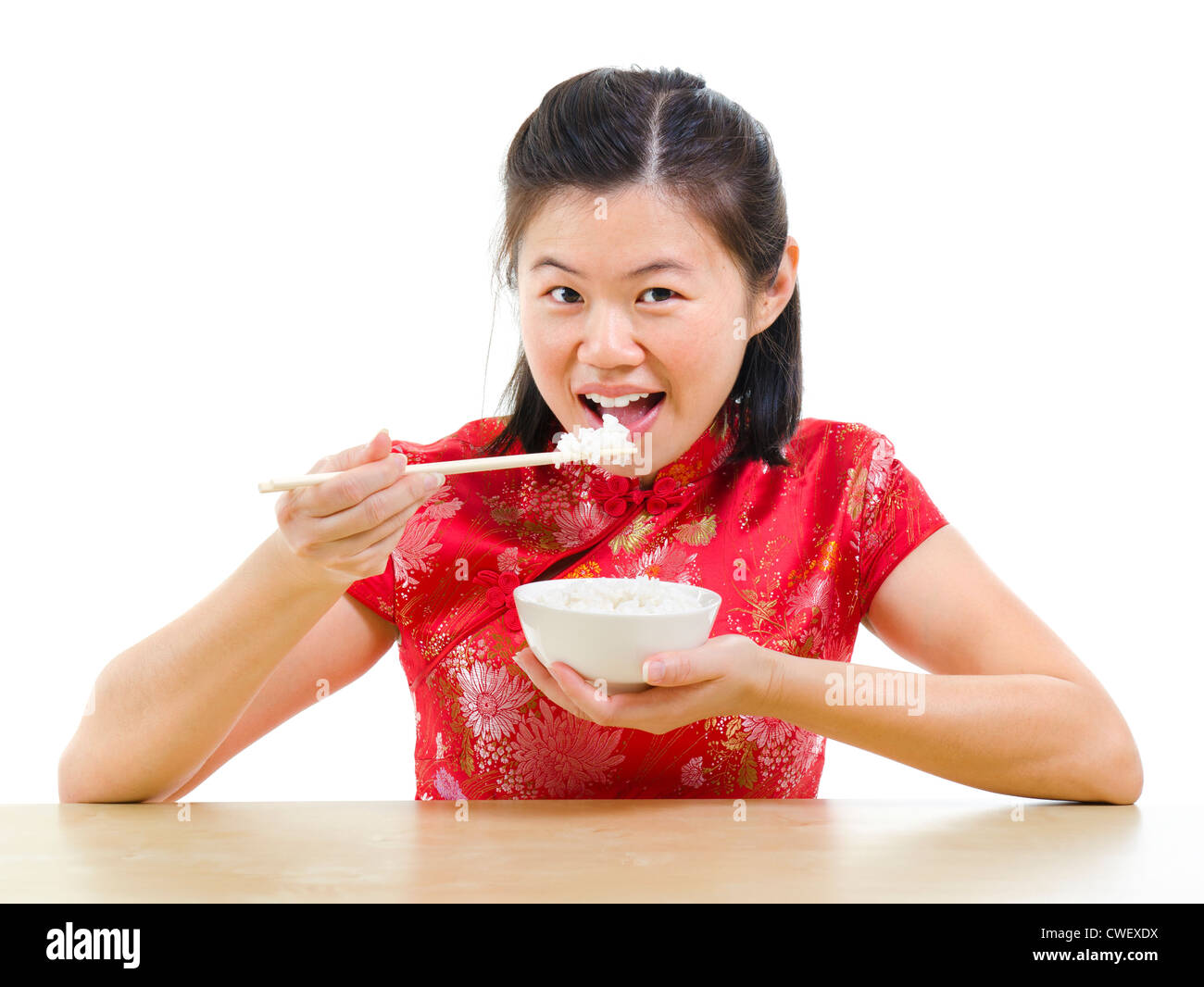 Asian woman eating rice with chopsticks over white background Stock ...