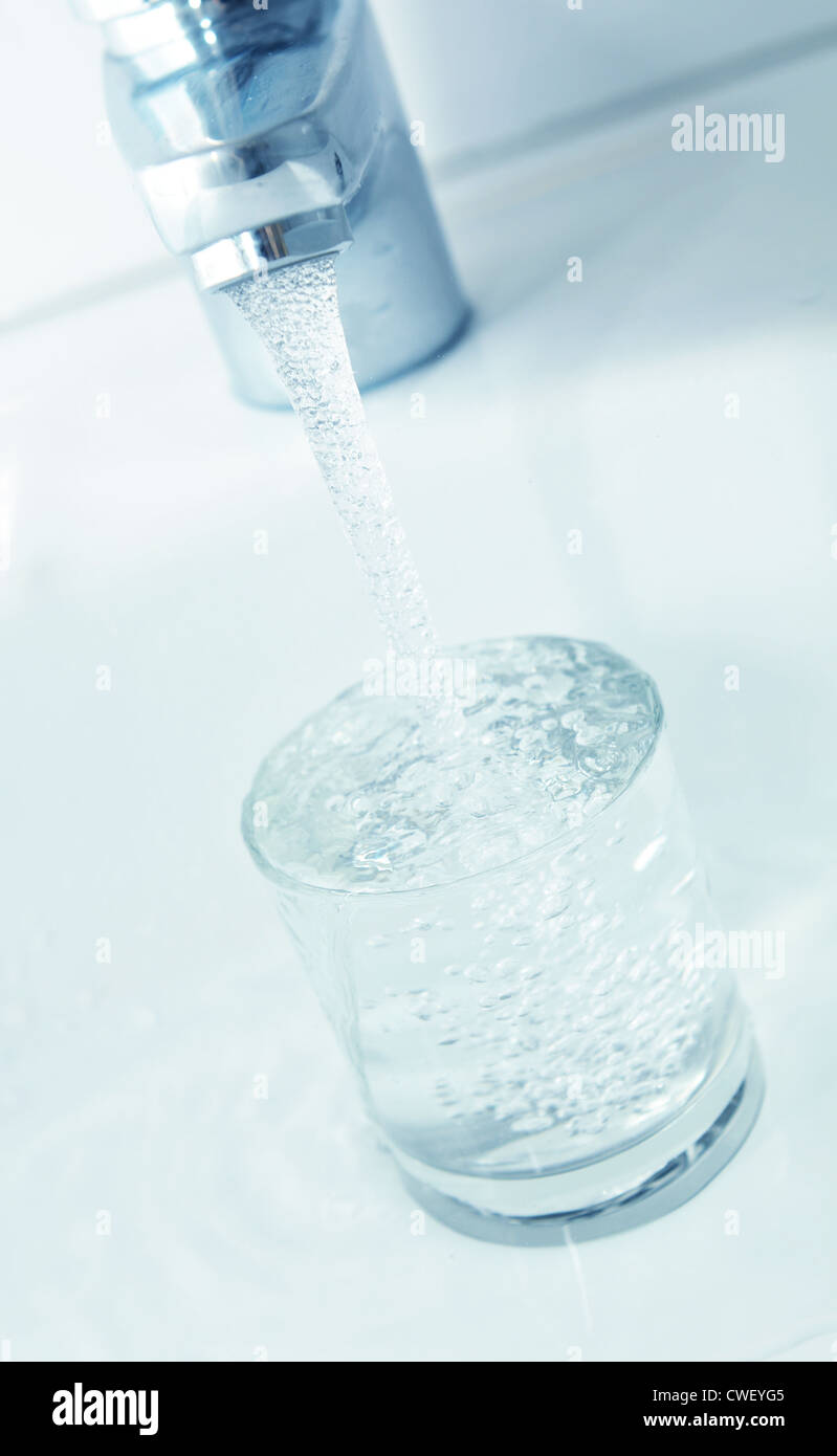 Detail of water tap and glass Stock Photo - Alamy