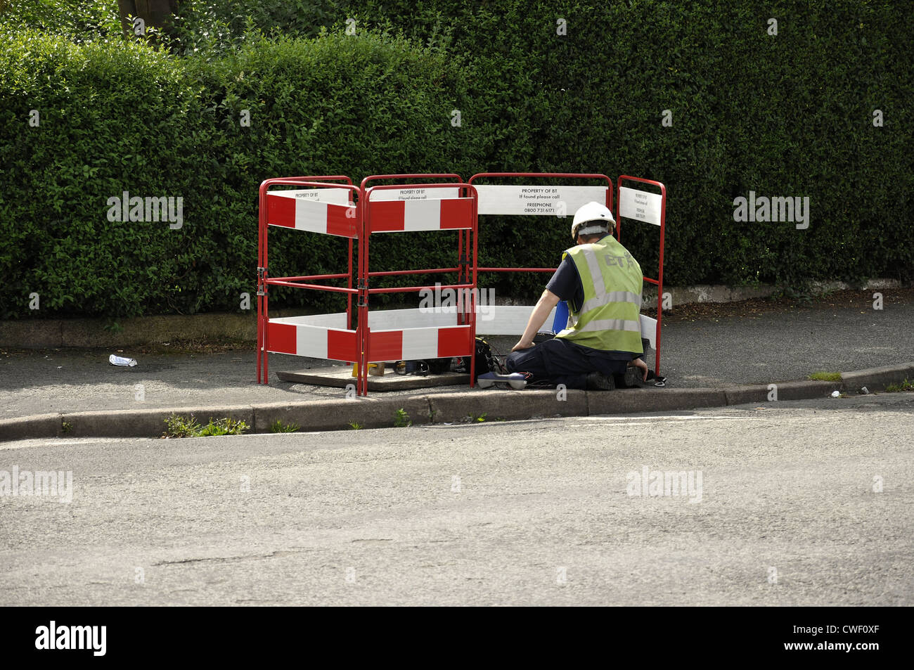 British Telecom engineer working on underground equipment with hazard ... British Telecom engineer working on underground equipment with hazard ...