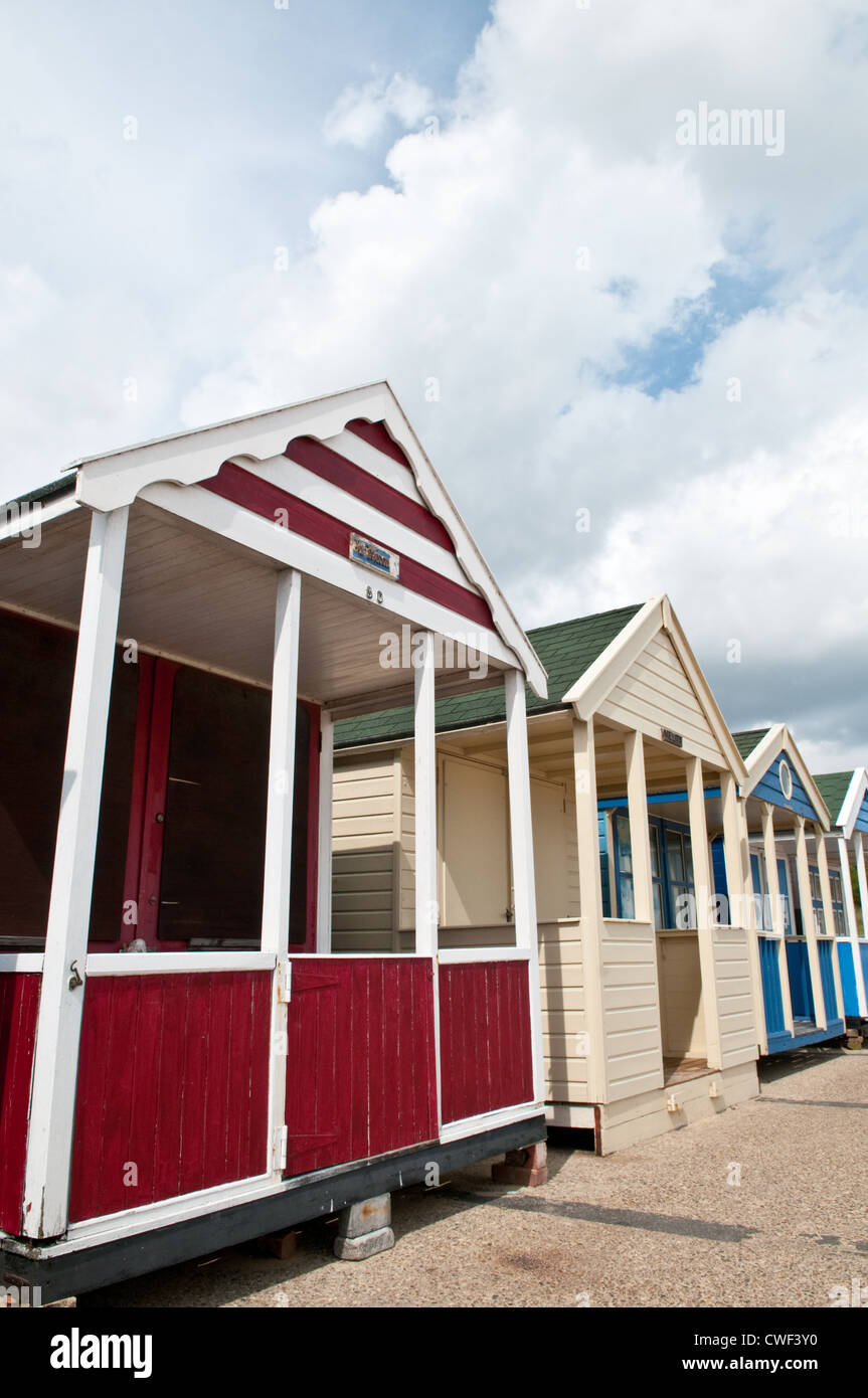 Expensive and desirable painted beach huts in red, cream and blue on ...