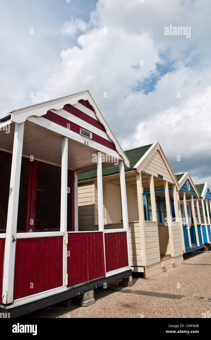 Expensive and desirable painted beach huts in red, cream and blue on ...