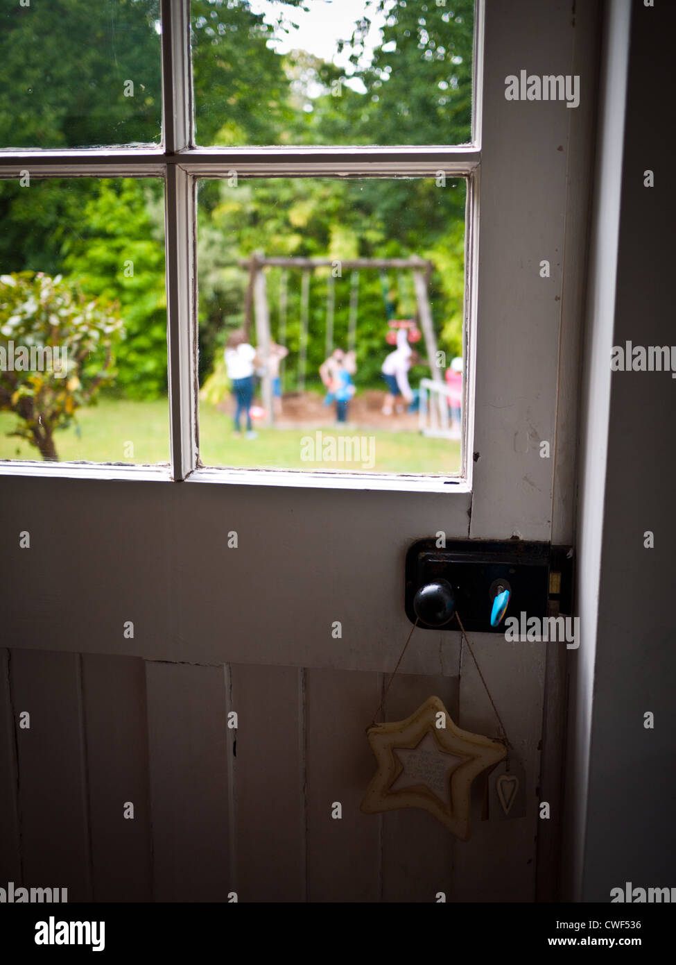 View of children playing in the back garden through the window of a ...