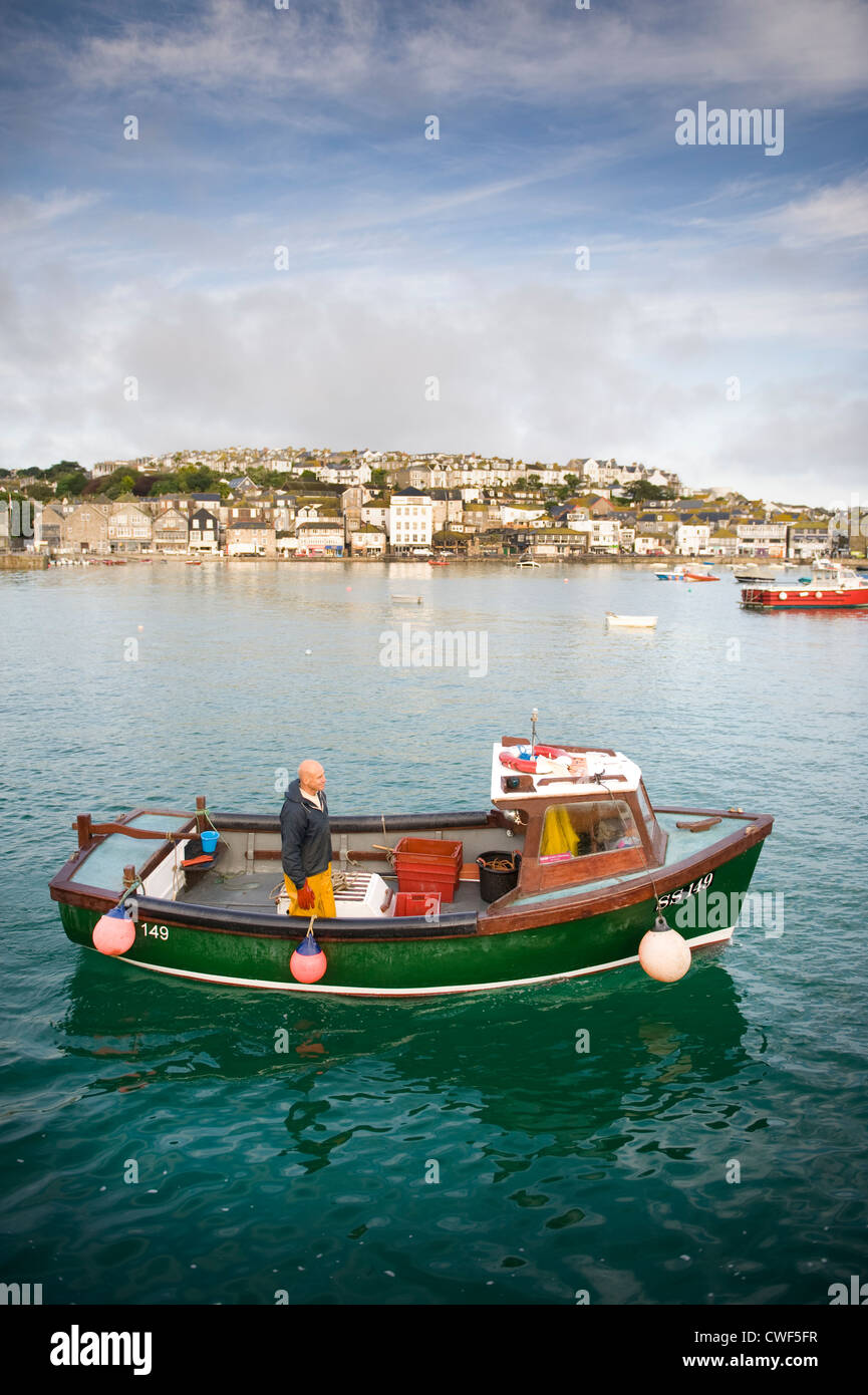 fisherman leaving or returning to harbour in a small fishing boat st ...