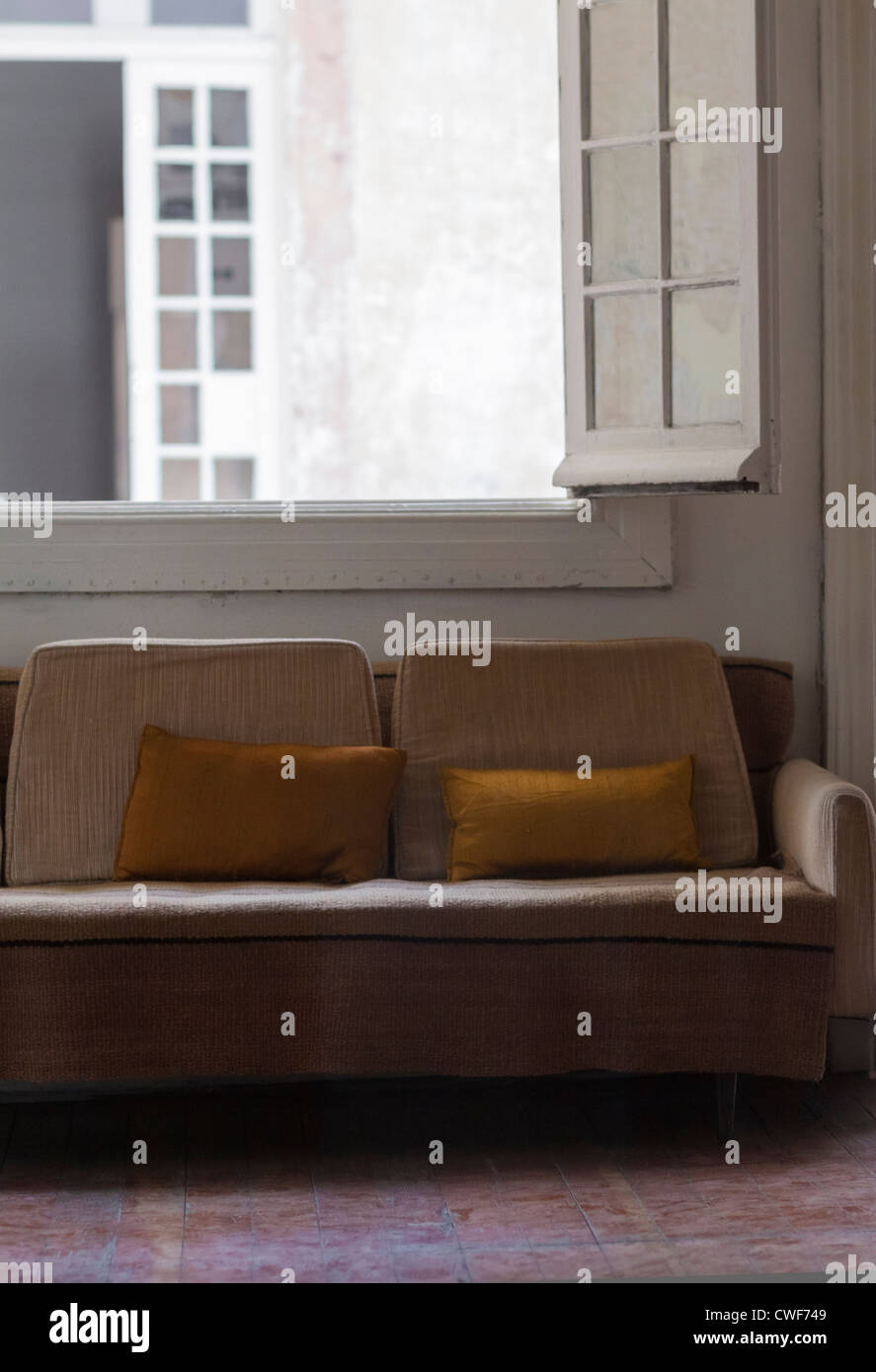 An indoor living room. A nice couch in front of a window Stock Photo ...