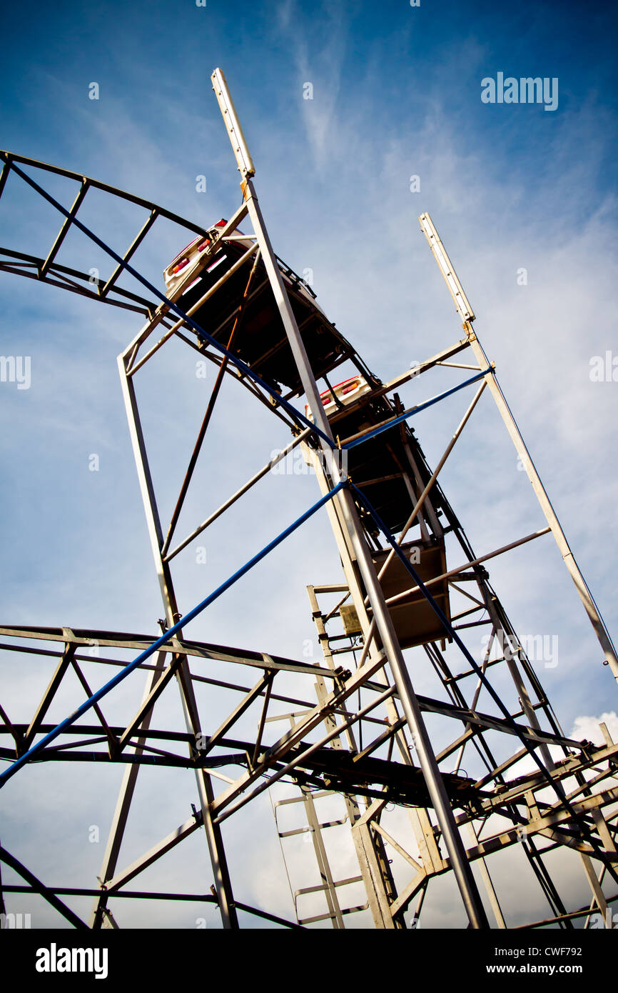 The carriage of a generic roller coaster travels high above along the ...