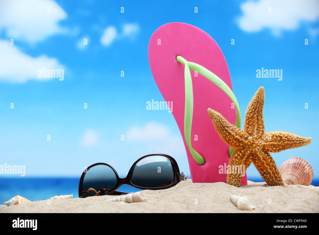 Flip-flops and sunglasses on sand beach Stock Photo - Alamy