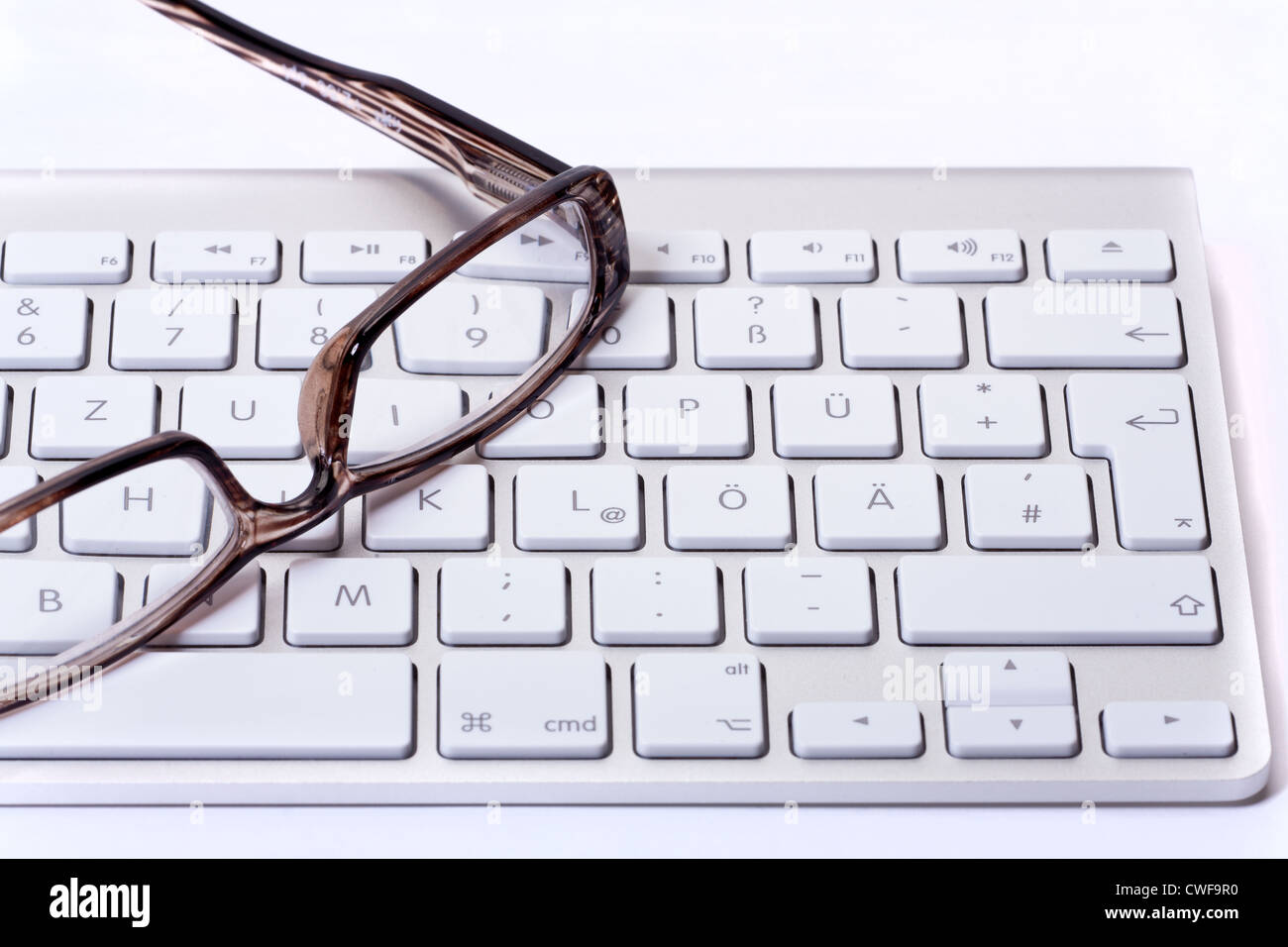 Computer Keyboard with a glasses on white background Stock Photo - Alamy
