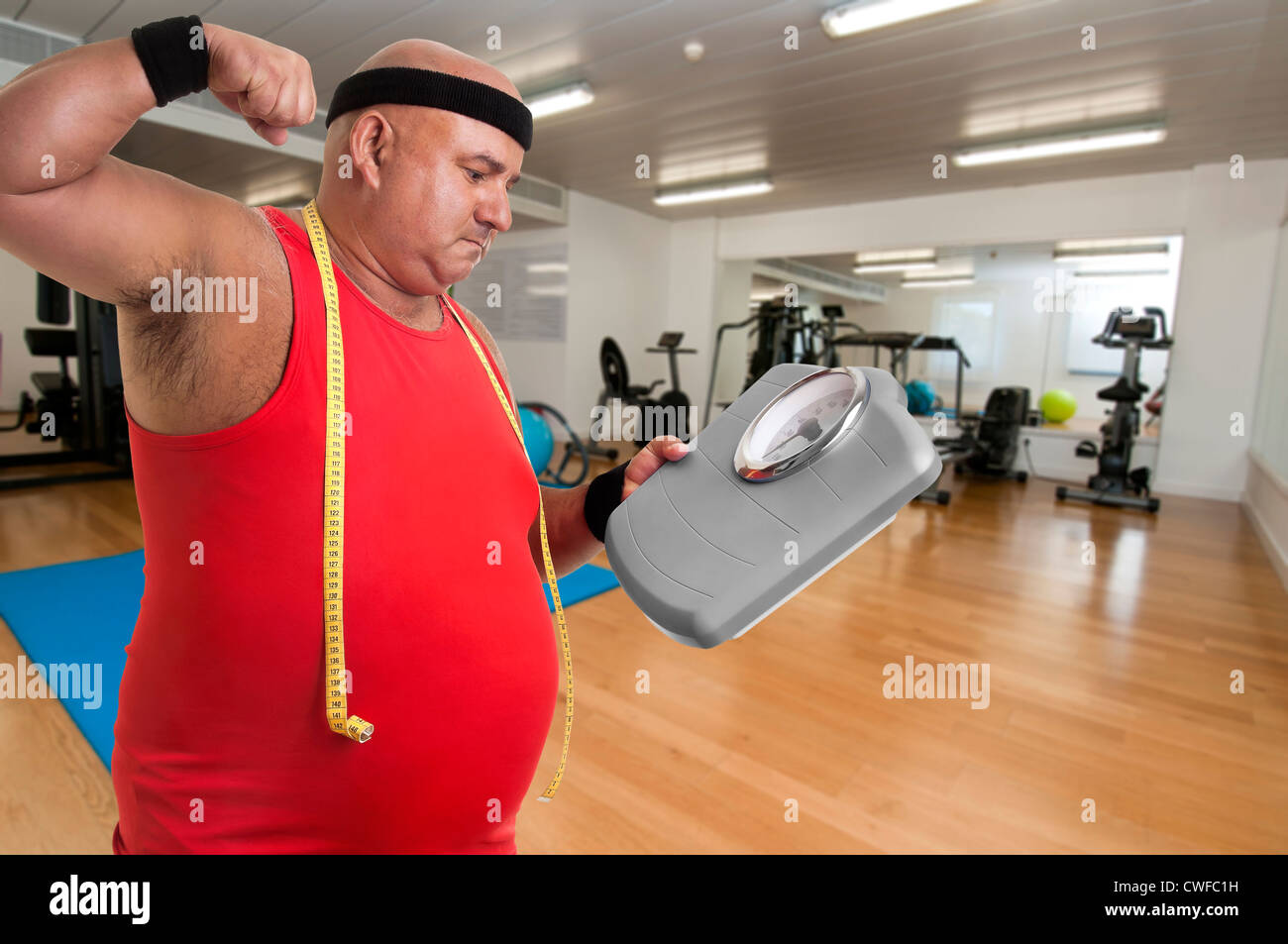 Large unhappy fitness man with weight scale in a gym Stock Photo - Alamy