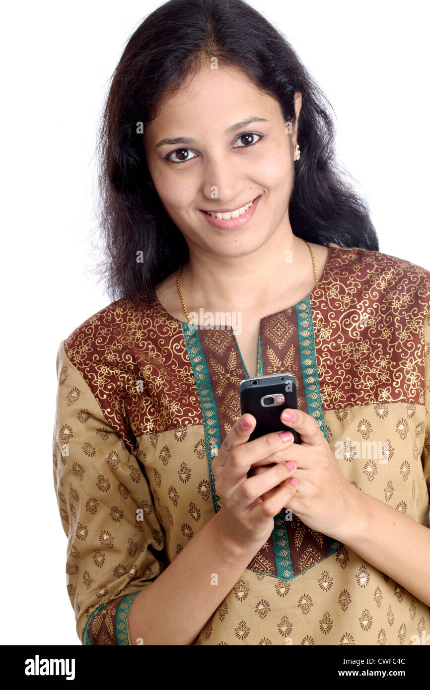 Smiling young Indian woman text messaging against white Stock Photo - Alamy