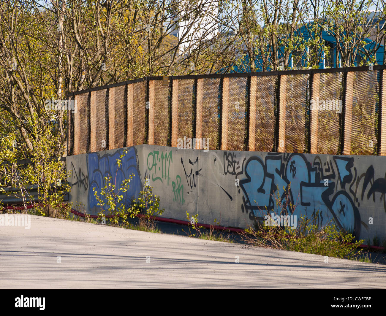 The rusty chain-link fencing on this old bridge with added graffiti is ...