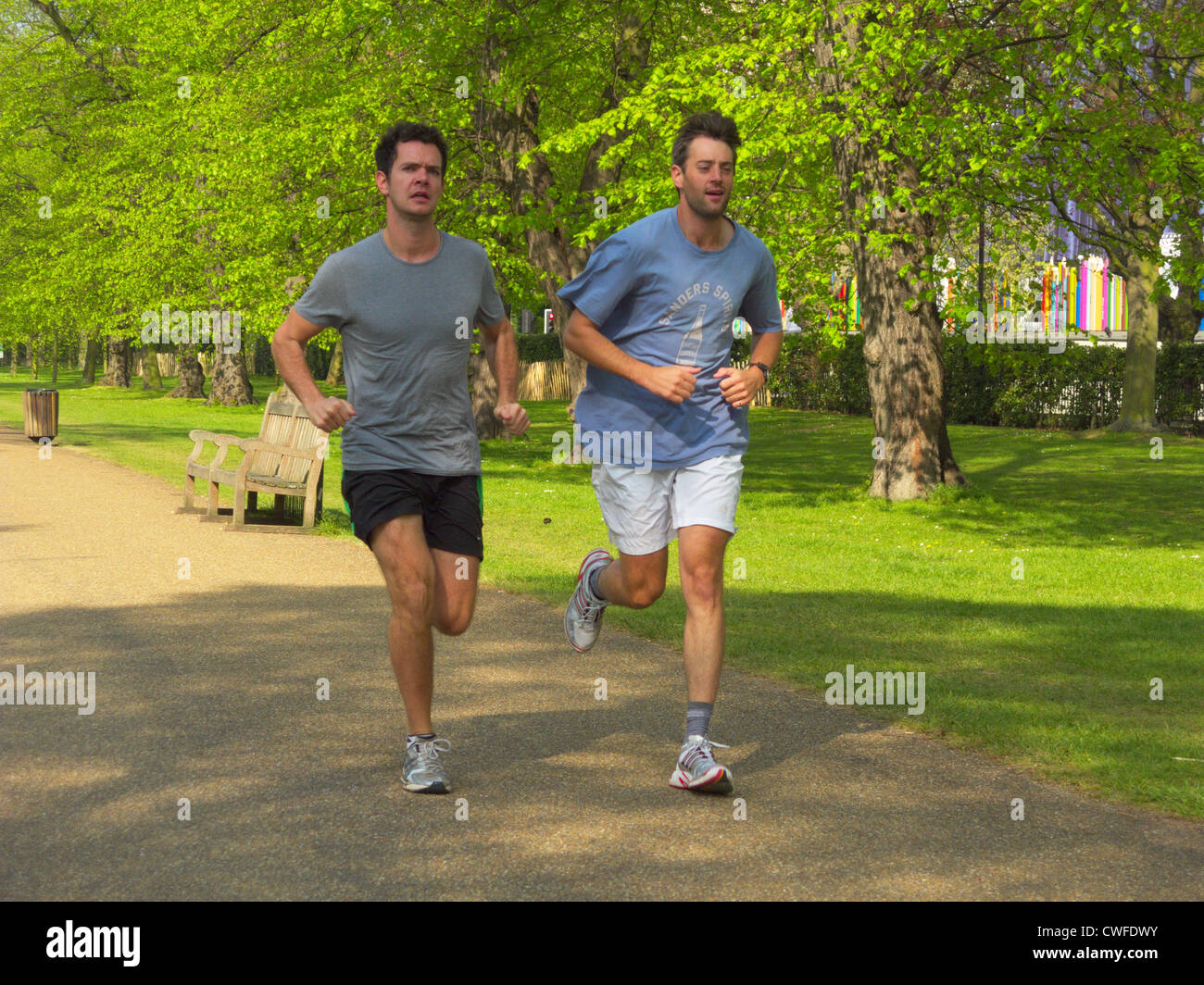 Two men jogging in Kensington Gardens public park, London, UK Stock ...