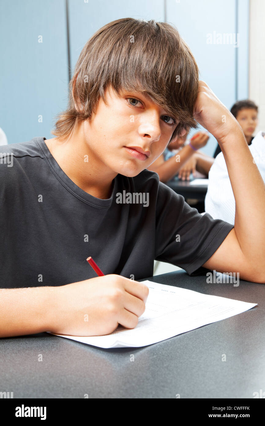 Serious adolescent school boy taking a test in class Stock Photo - Alamy
