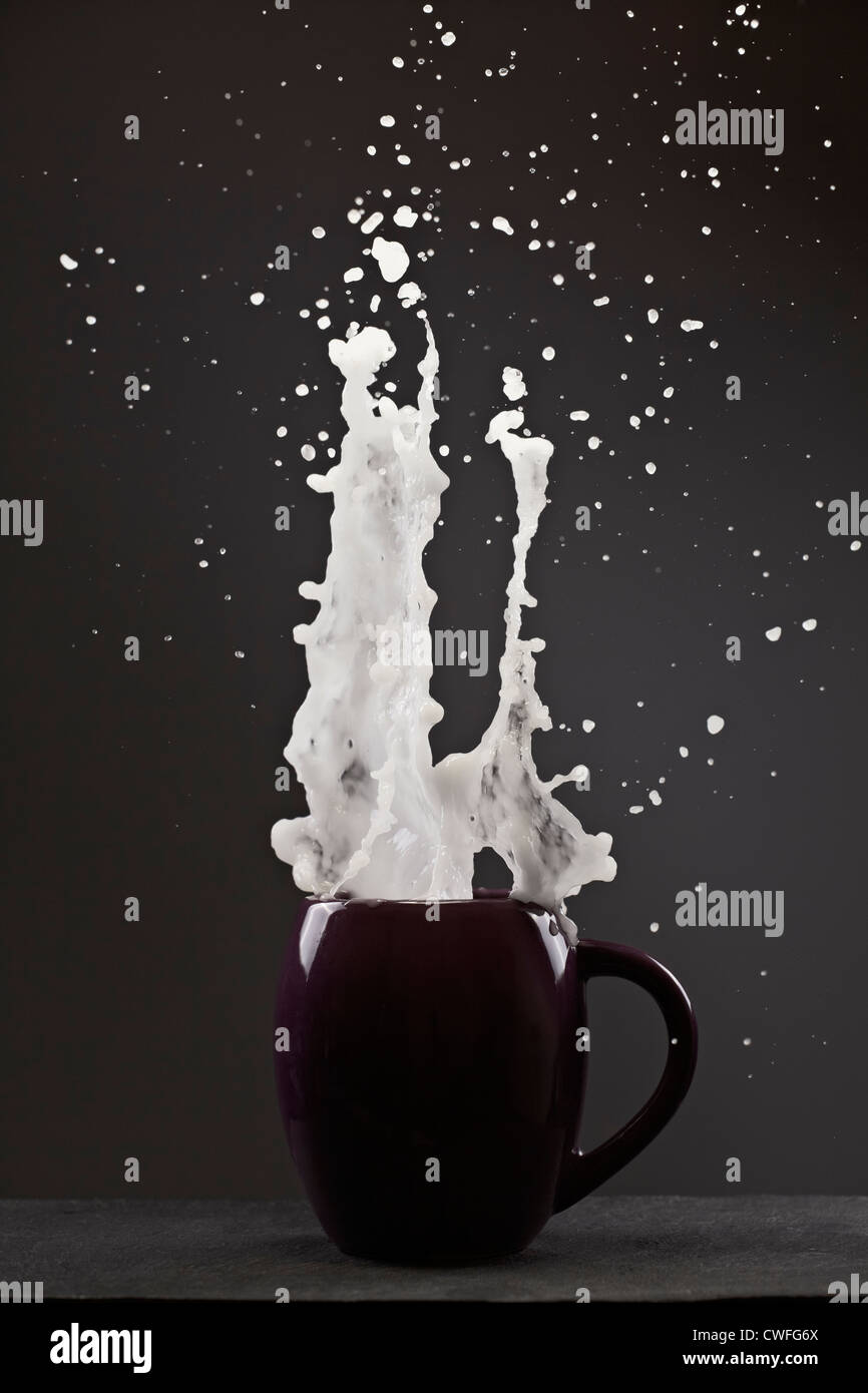 White liquid exploding out of a mug Stock Photo - Alamy