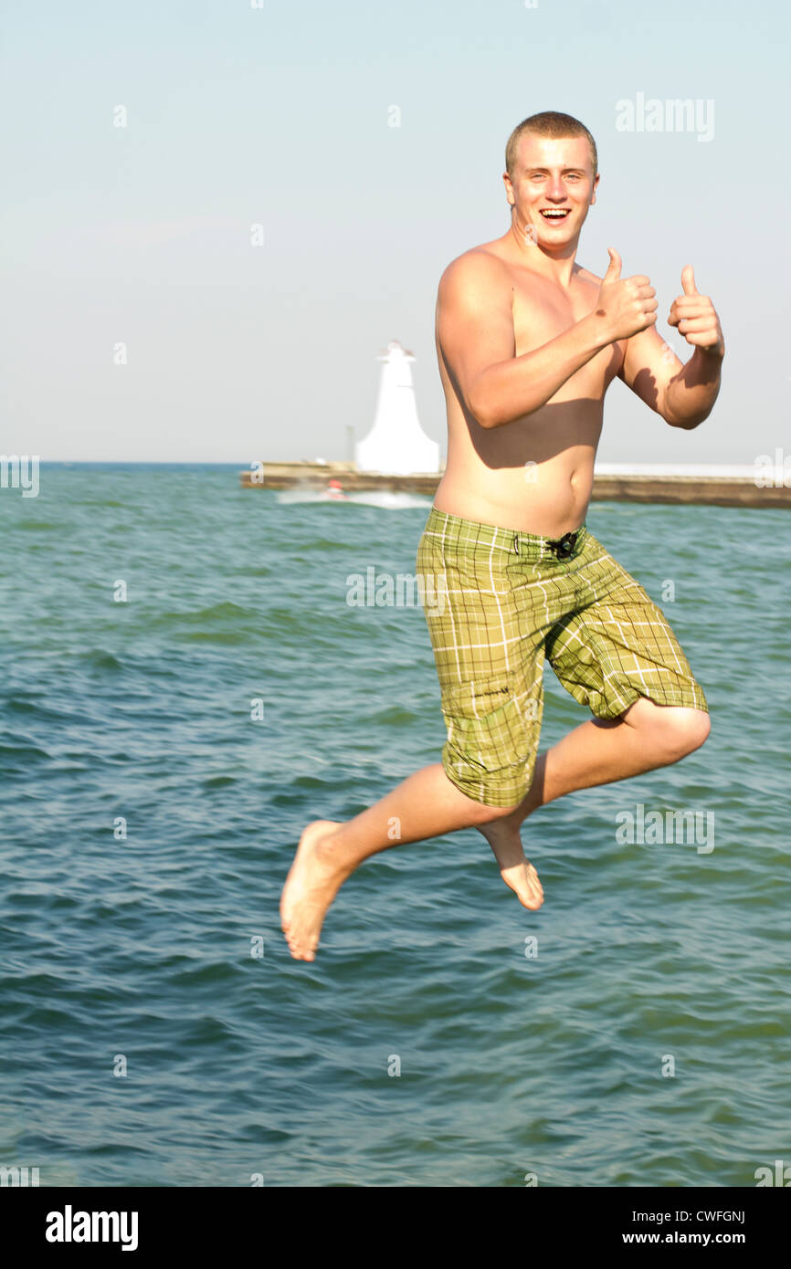 Boy jumping over water Stock Photo - Alamy