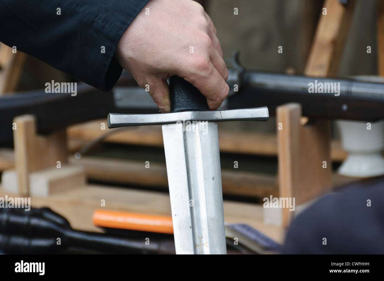 Male hand holding a the haft of a medieval sword - Detail of the upper ...