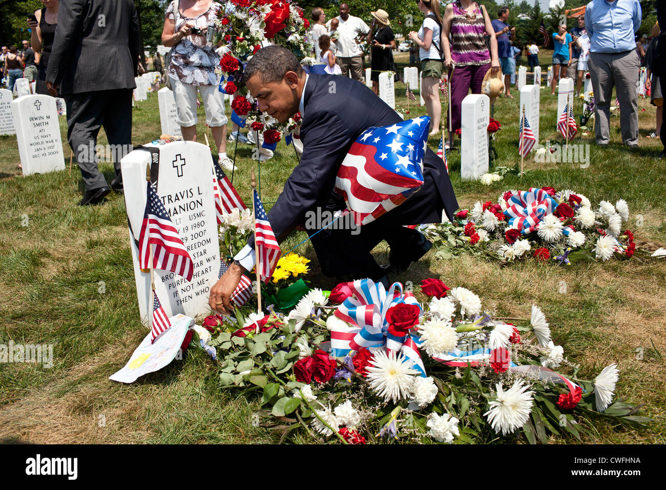President Barack Obama lays a Presidential challenge coin on a grave in ...