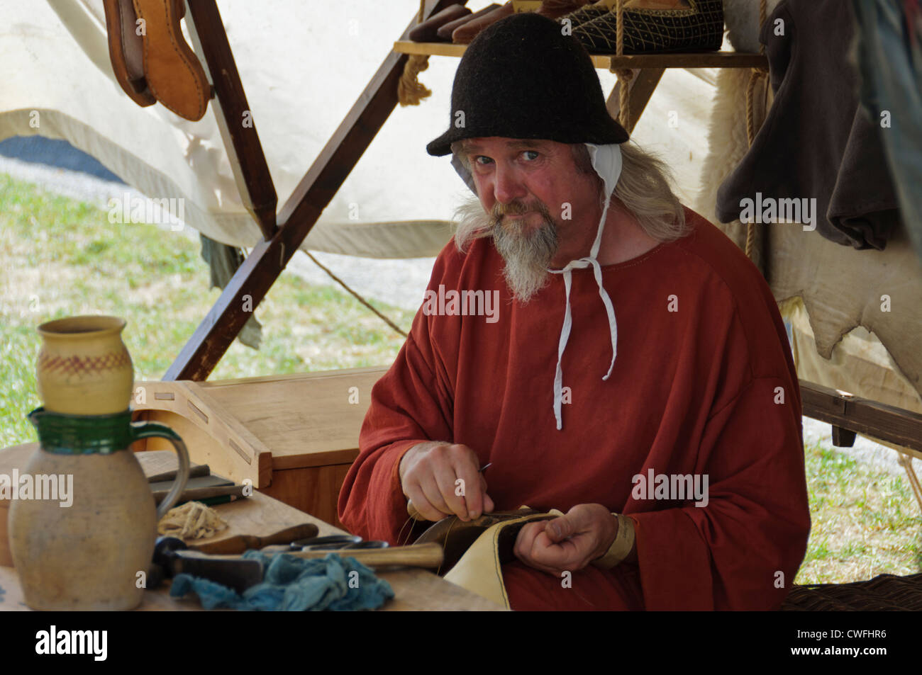 Male craftsman shows ancient handcraft at an medieval market ...