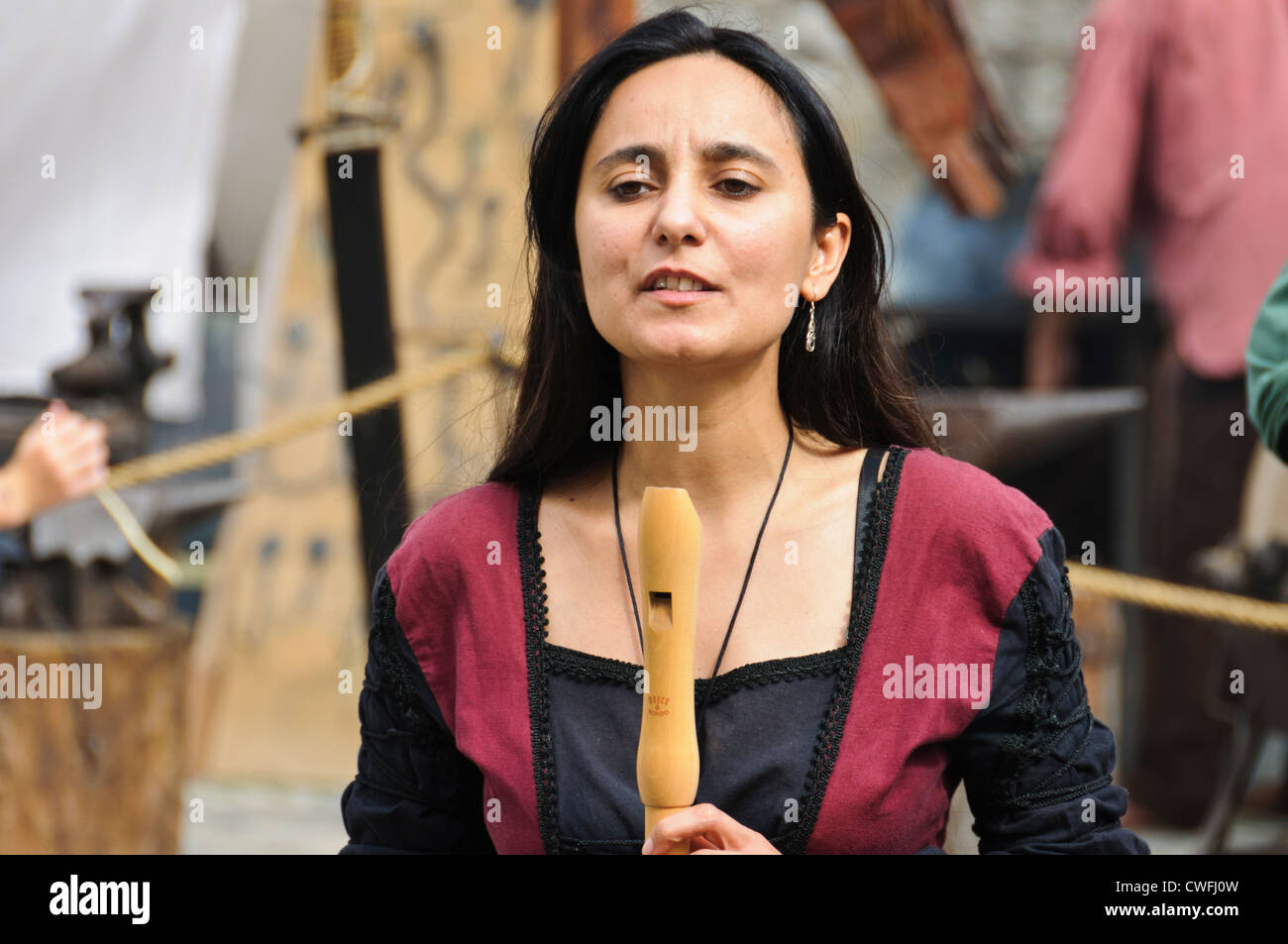 Female flutist with black hair in historic clothing, fipple flute ...