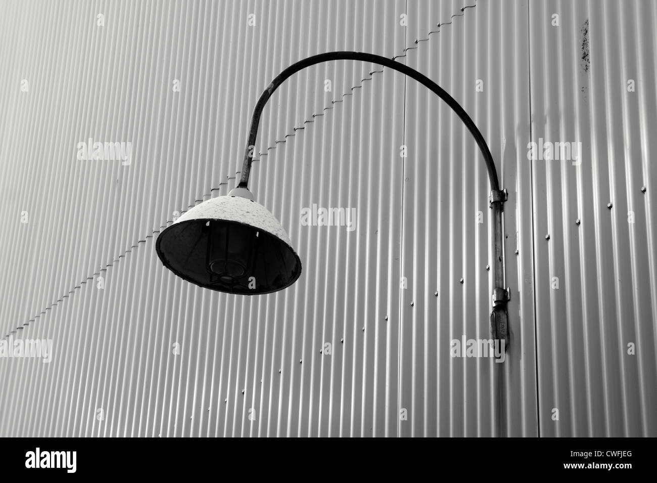 Electric light fixture on wall of a corrugated metal building ...