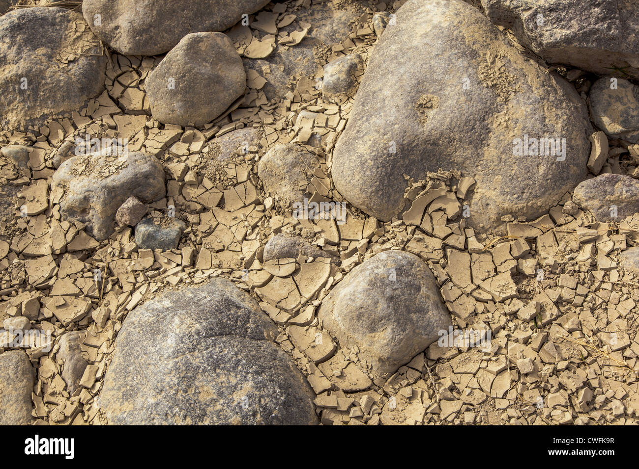 Patchwork of cracked dry mud and rocks caused by severe drought in ...
