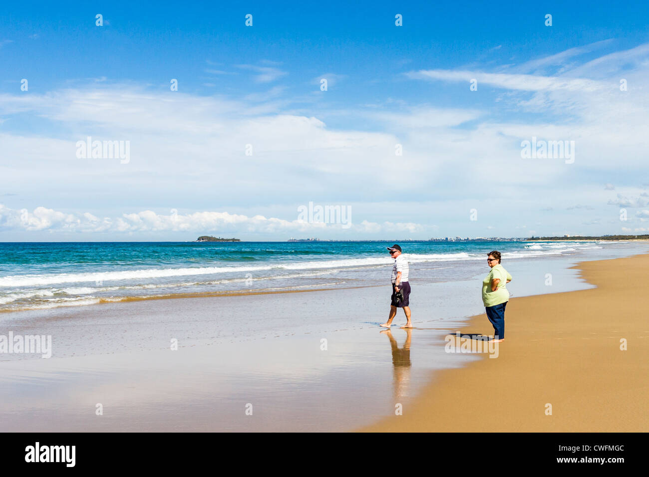 Senior couple wading on deserted beach at Marcoola, Sunshine Coast ...