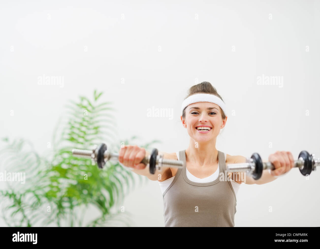 Young sport woman making exercise with dumbbells Stock Photo - Alamy