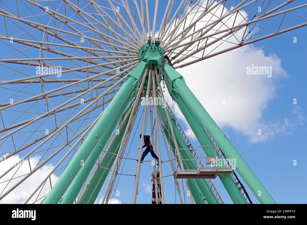 Worker constructing a fairground big wheel Stock Photo - Alamy