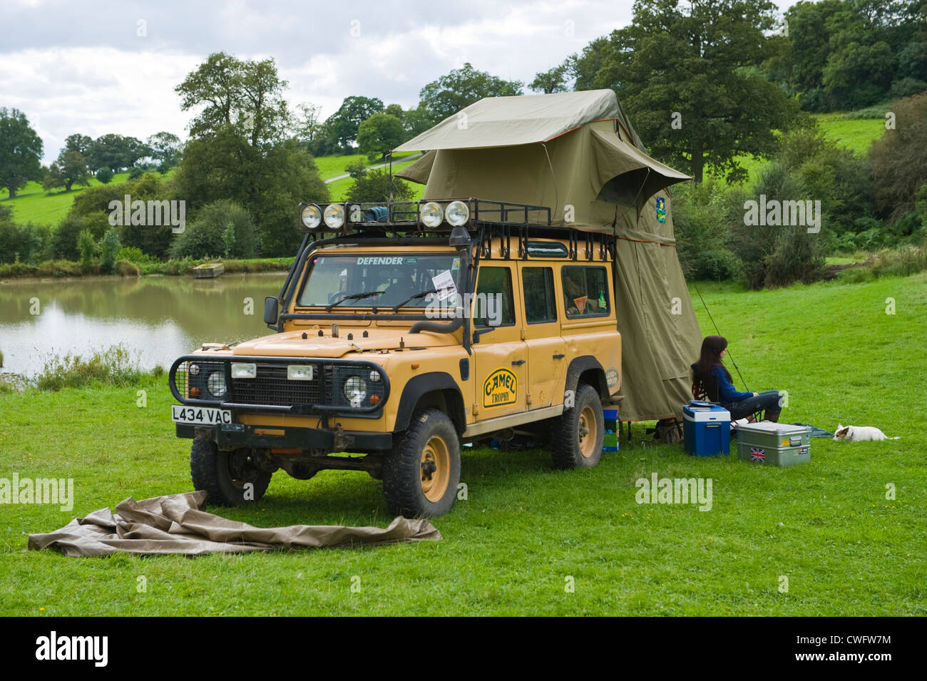 CAMEL TROPHY Land Rover Defender 110 camping at lakeside in countryside ...