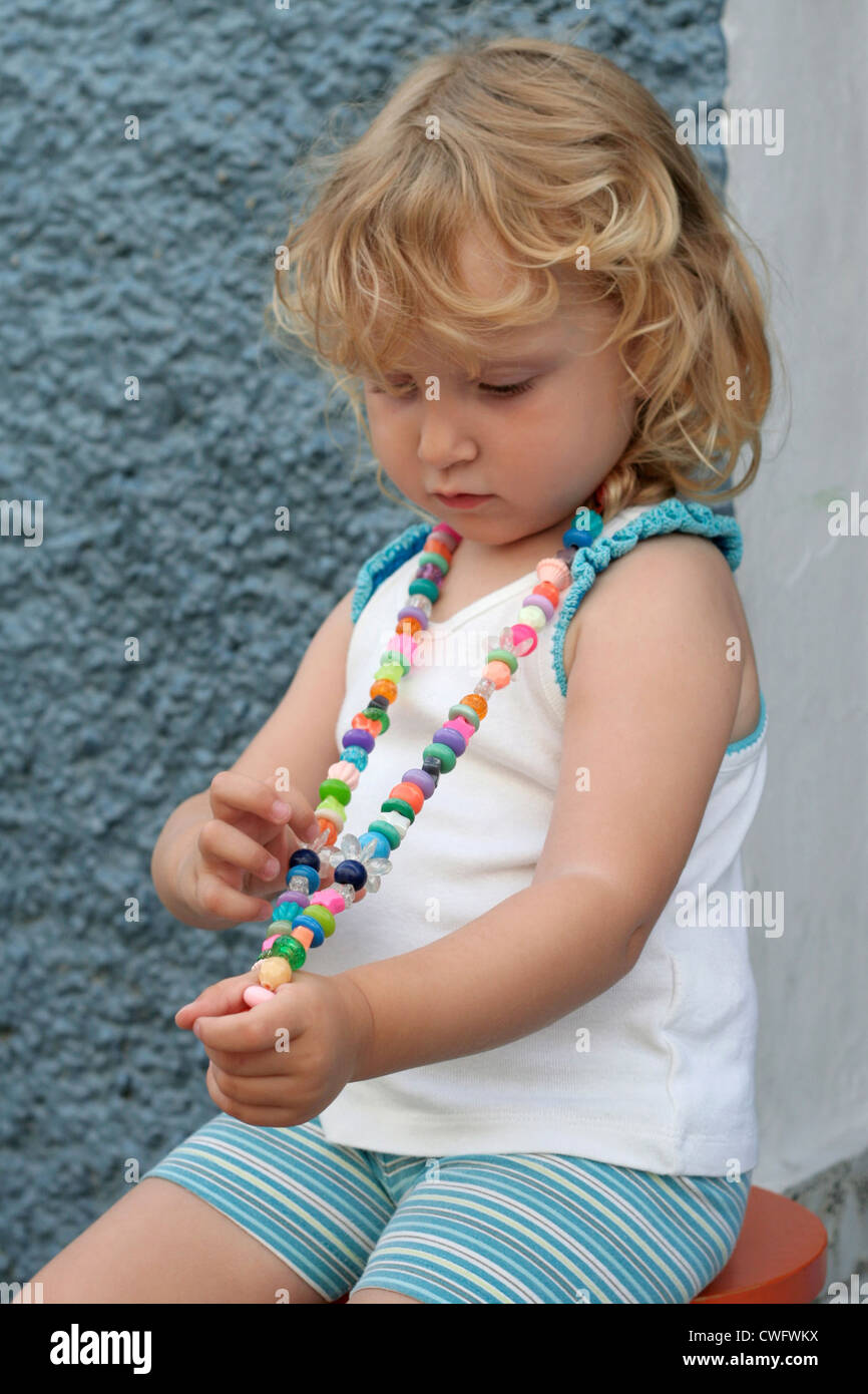 Little girl plays with a chain Stock Photo - Alamy