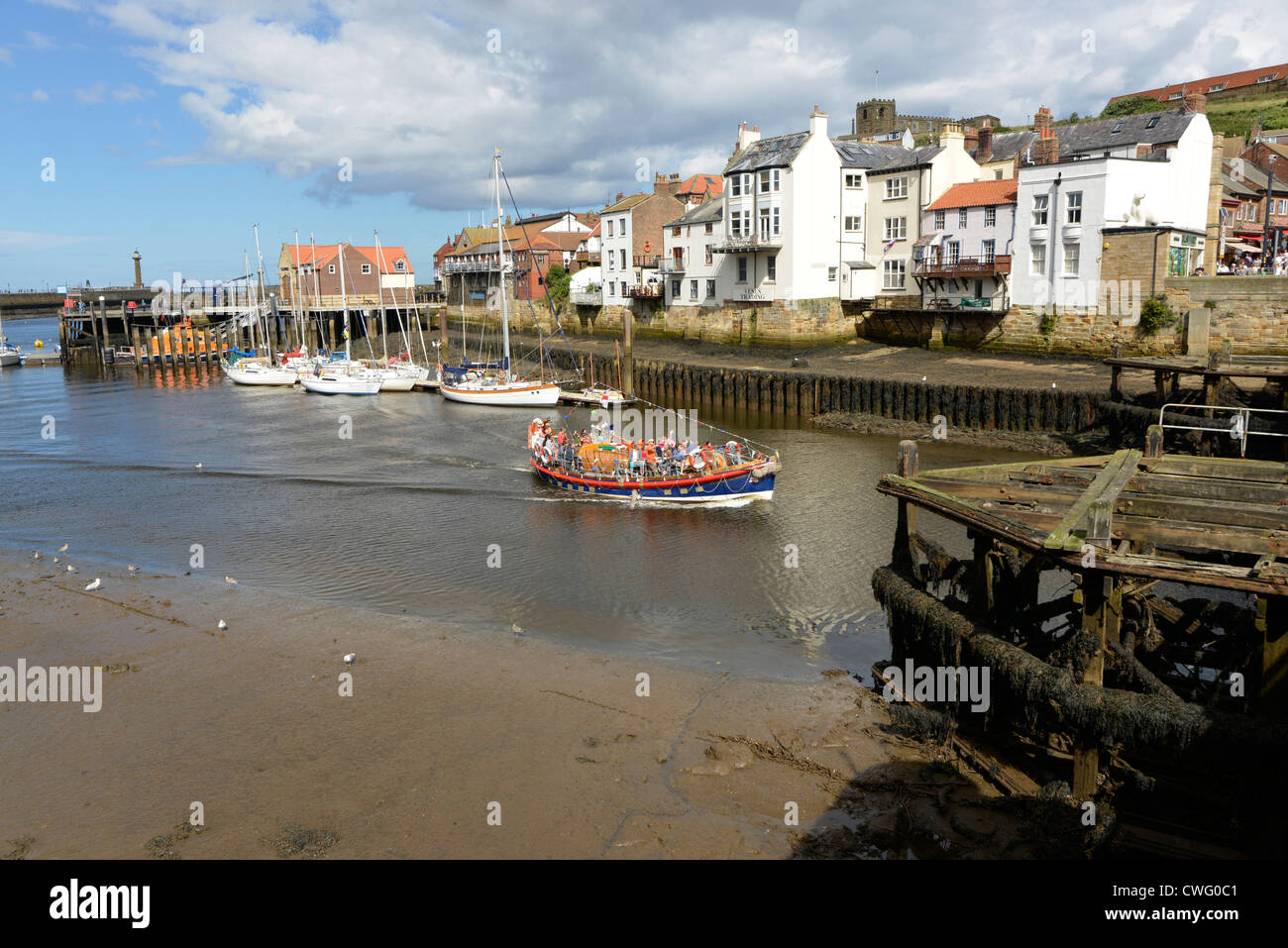 a pleasure boat comes in to dock at whitby harbour Stock Photo - Alamy