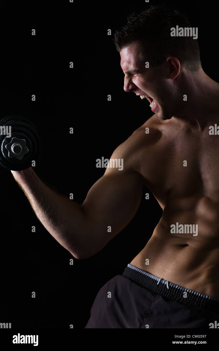 Angry muscular athlete workout biceps on black Stock Photo - Alamy