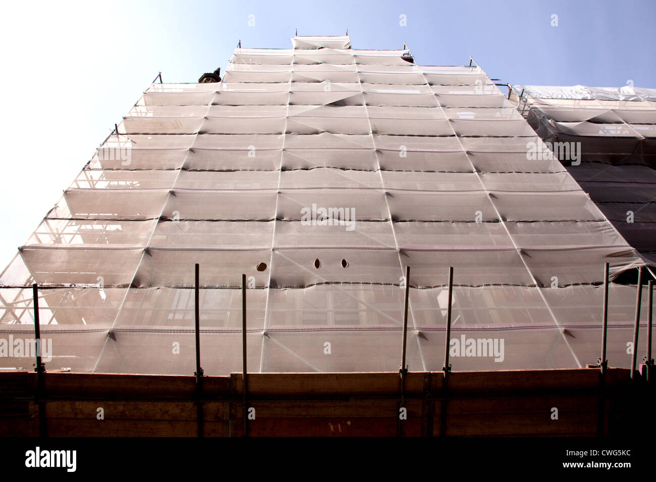 scaffolding with safety net on building being renovated Stock Photo - Alamy