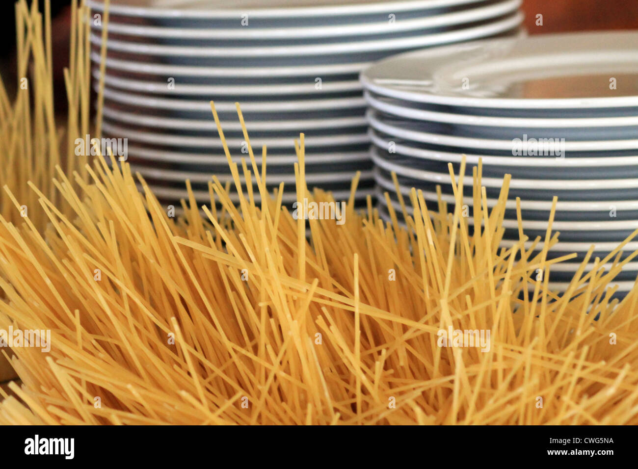 Pasta and stacks of plates in restaurant, food background Stock Photo ...