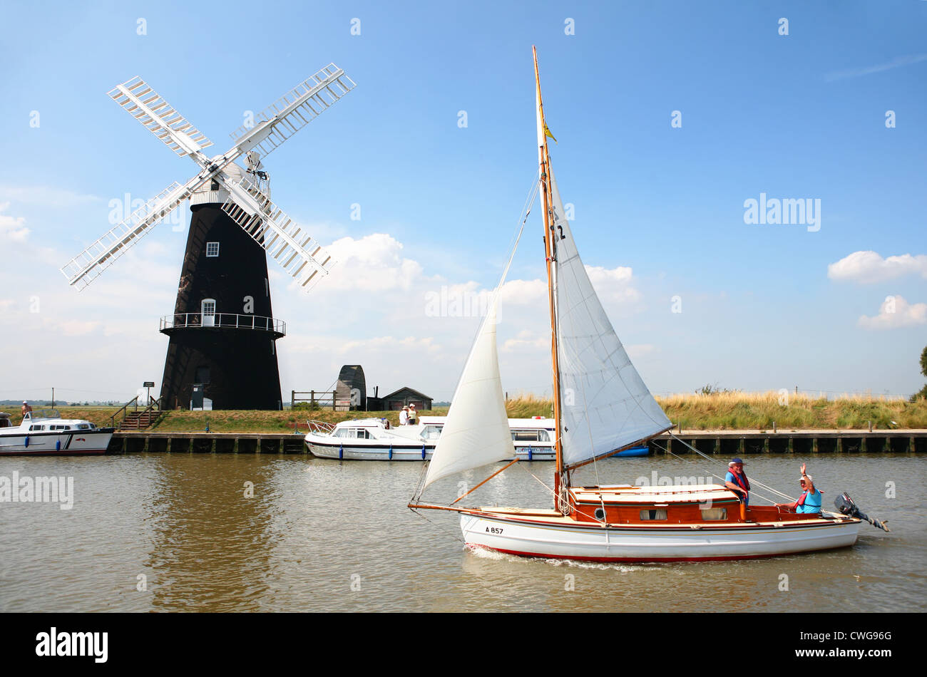A small sailing boat on the River Yare in Norfolk, England, with other ...