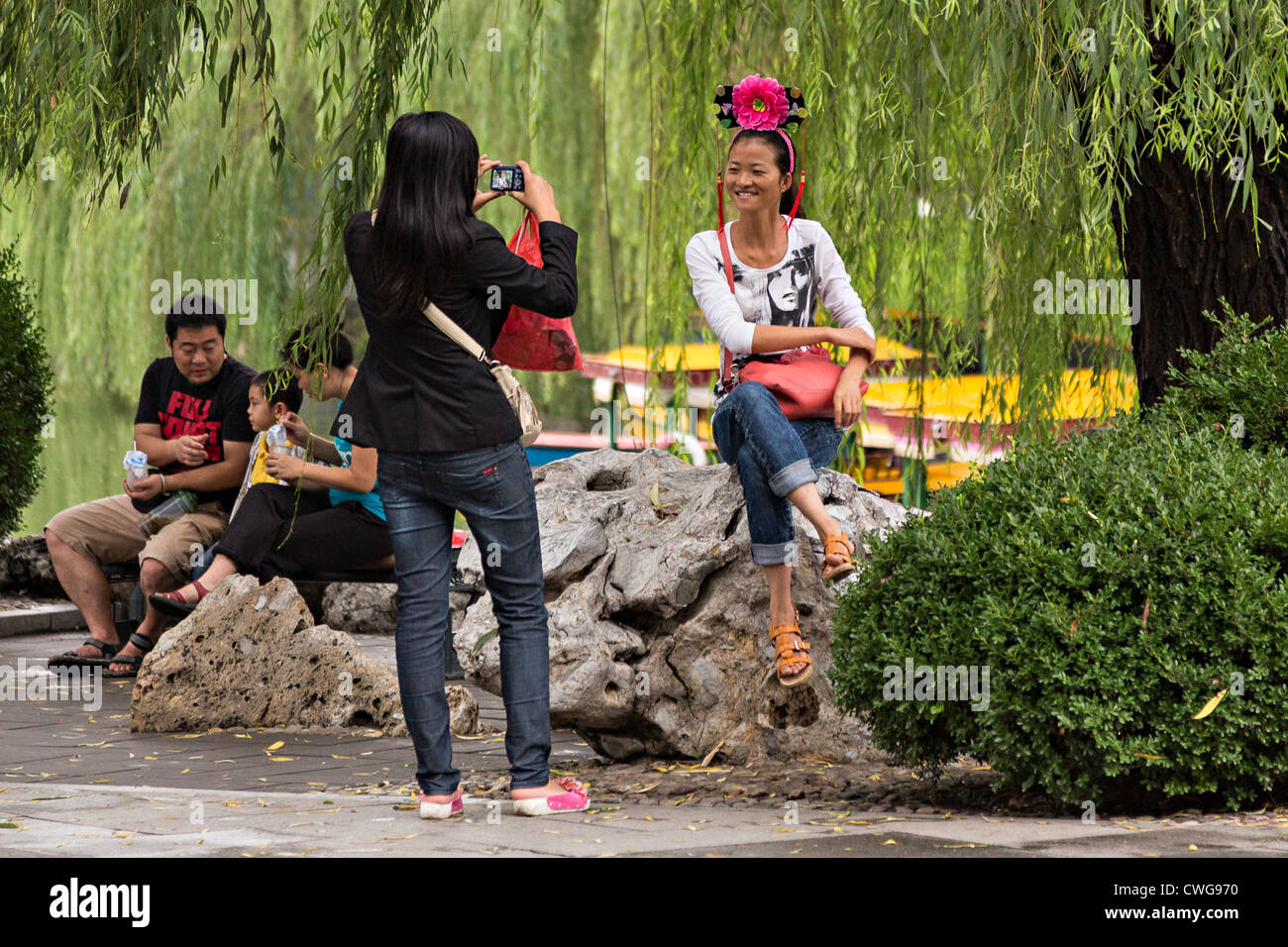 A woman has her picture taken wearing a traditional headdress at Beihai ...