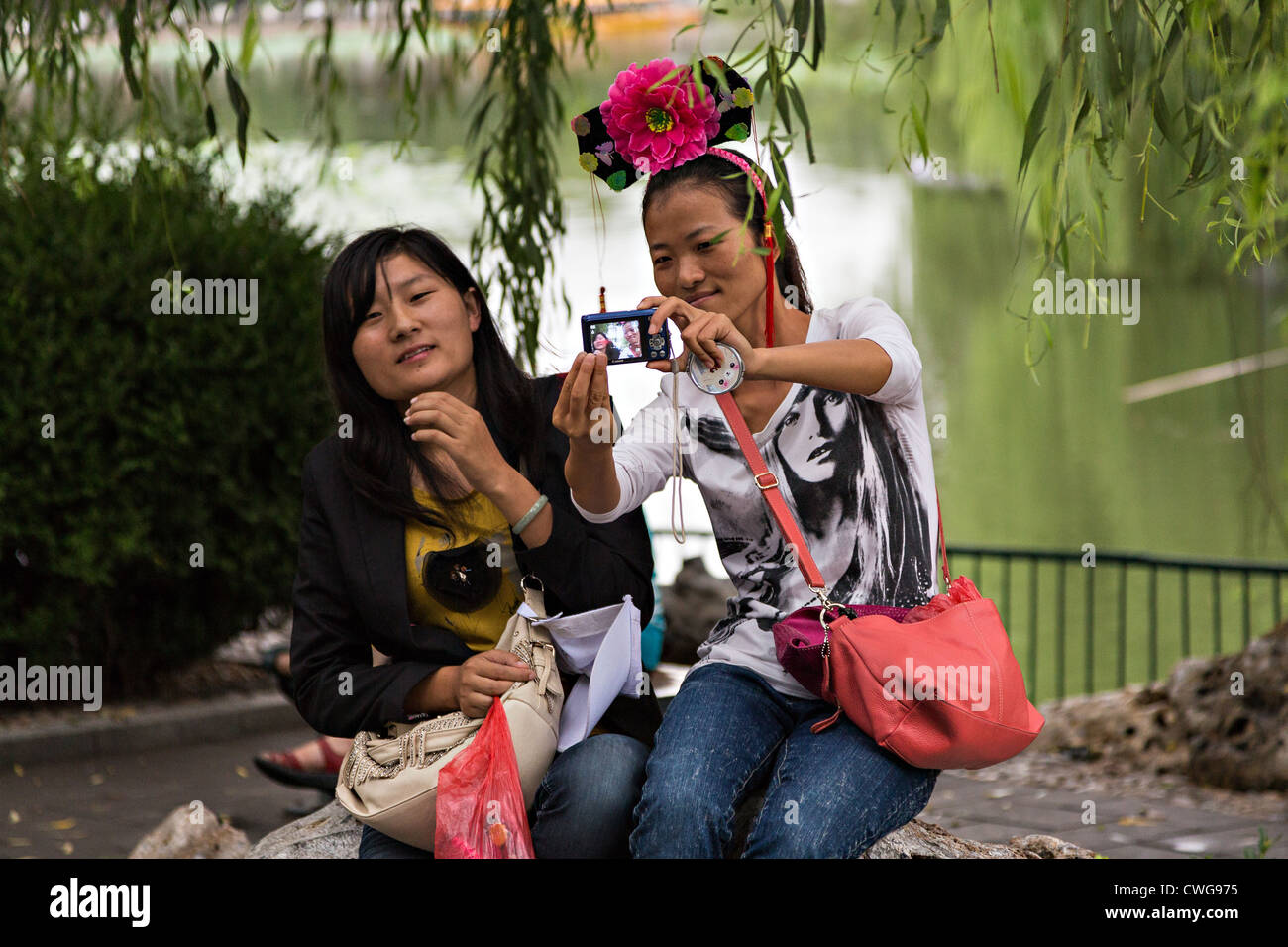 A woman has her picture taken wearing a traditional headdress at Beihai ...