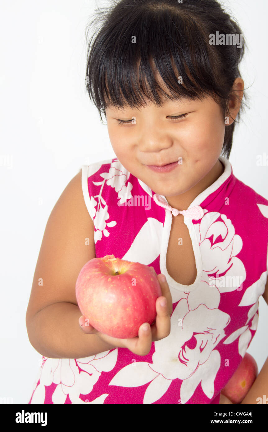 Is eating apple's little girl smile Stock Photo - Alamy