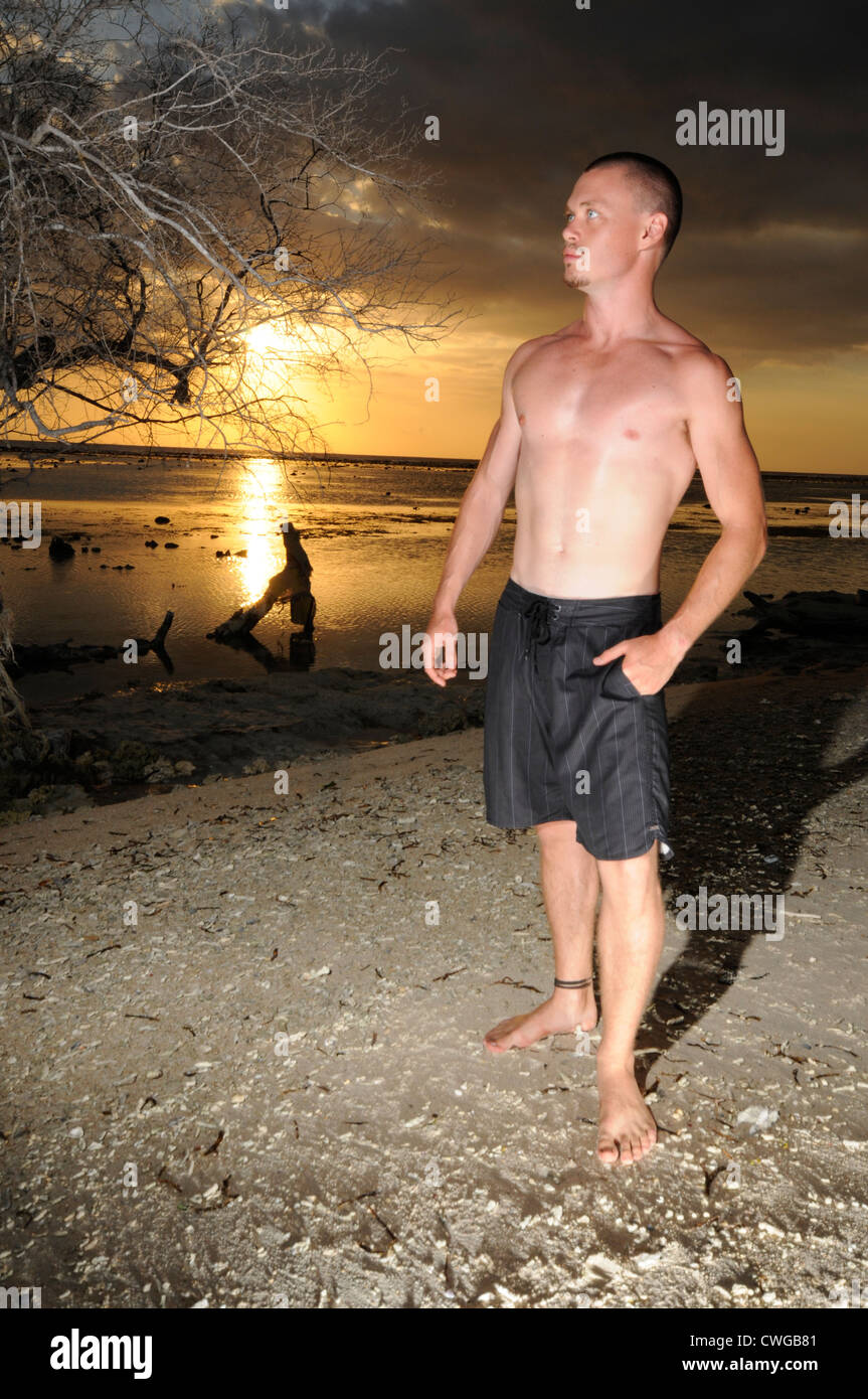 man posing on a beach with sunset Stock Photo - Alamy