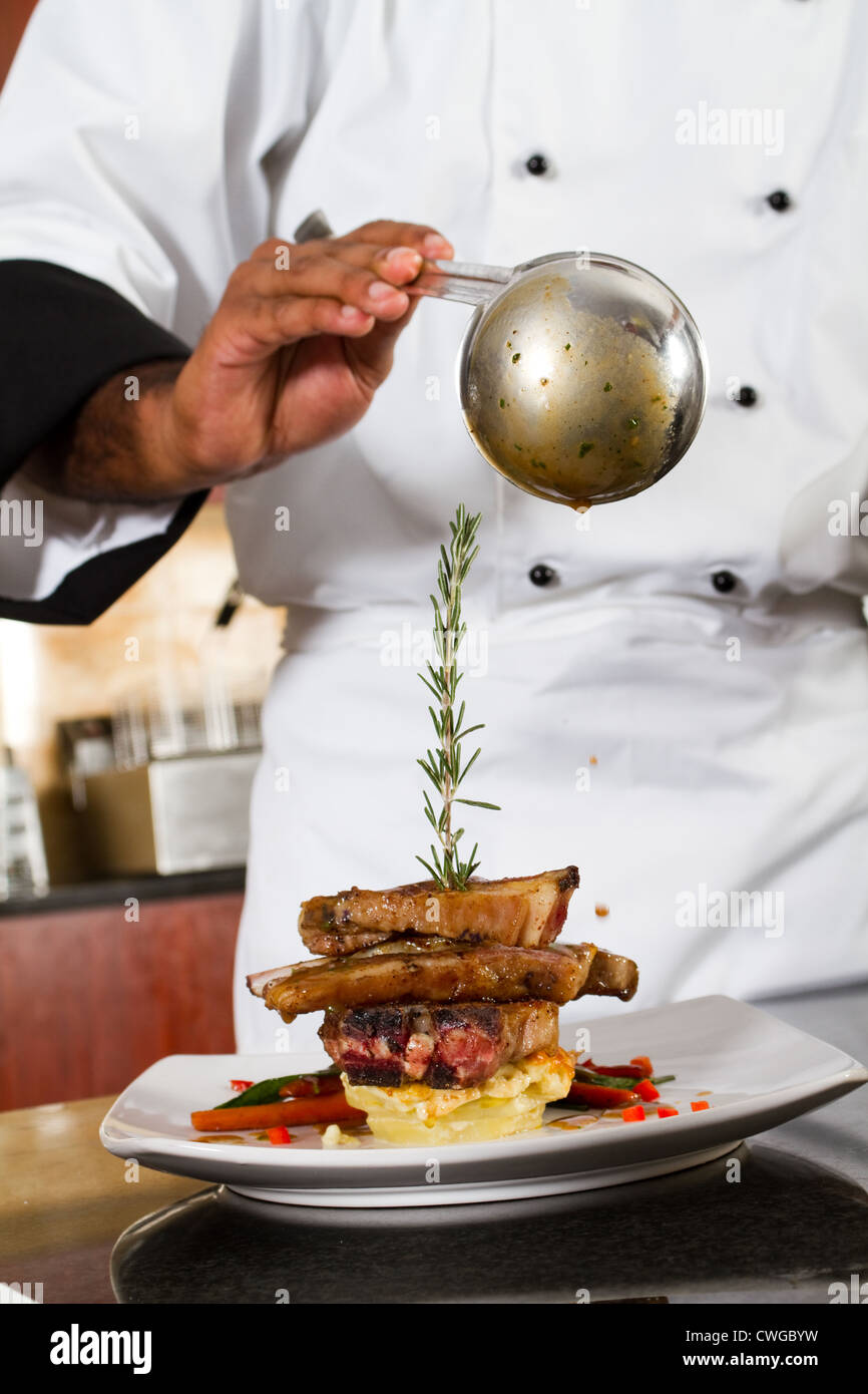 chef adding sauce to meat dish Stock Photo - Alamy