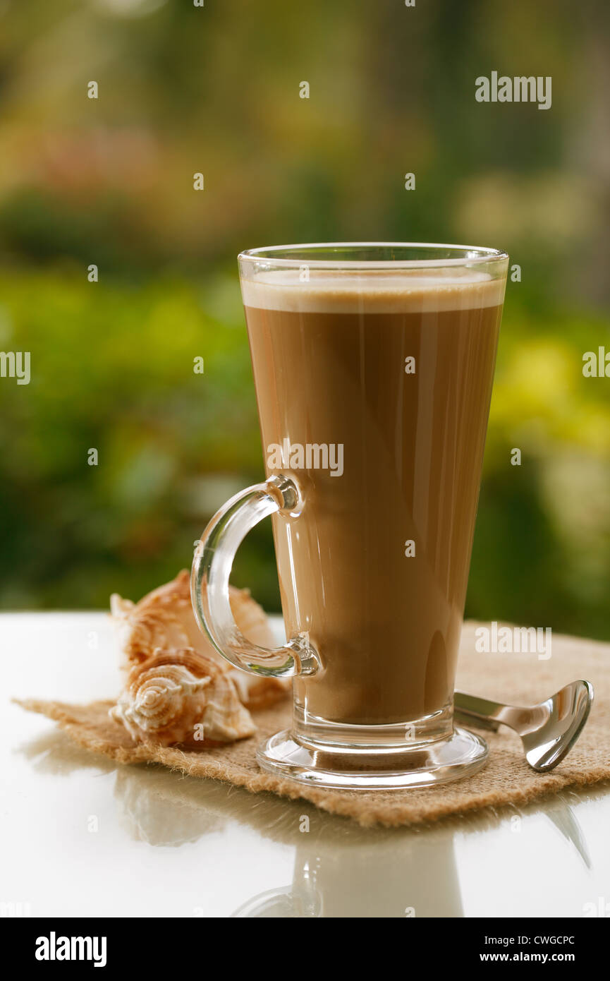 coffee latte in sky, palm tree and sunset background, warm light ...