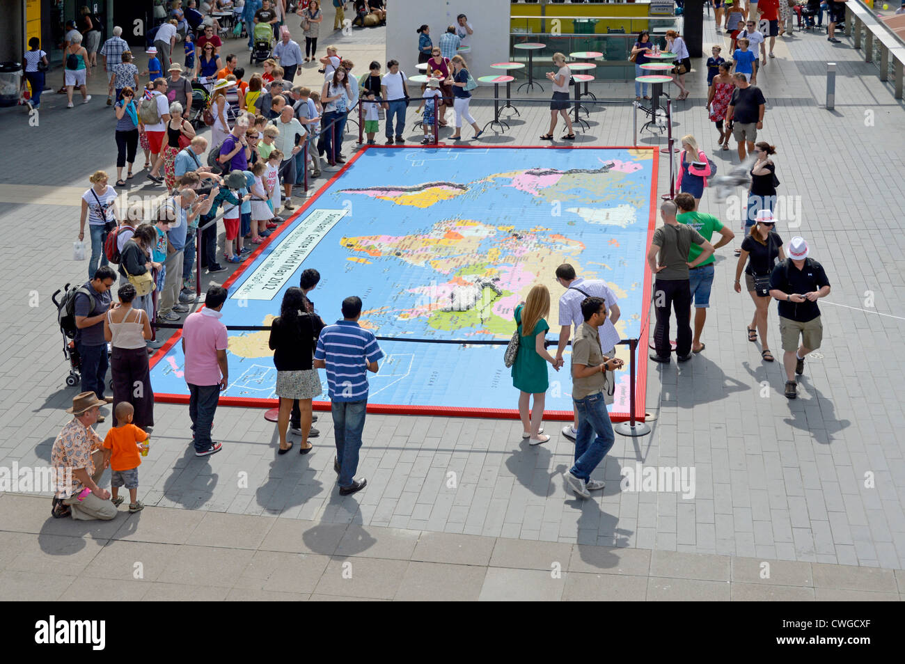 Aerial view Londoners & tourists viewing part world map representation ...
