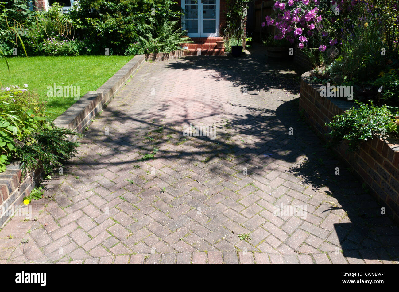 Brick paved driveway on a slight slope in front of a suburban house ...