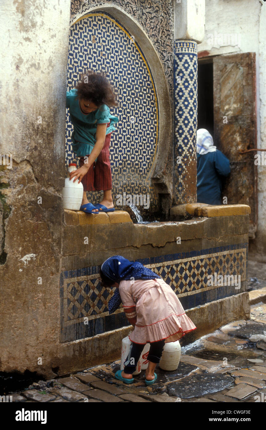Children fetching water at a public fountain Fez Morocco Stock Photo ...